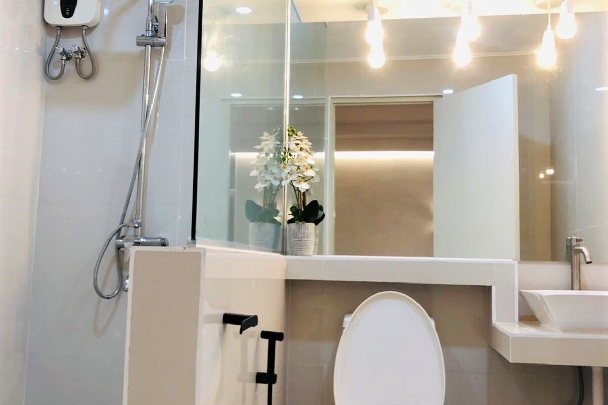 Uma casa de banho moderna com sanita, chuveiro e lavatório.