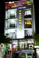 Um hotel com um letreiro de neon chamativo, várias sacadas e uma entrada visível.
