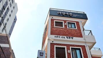 Um edifício de vários andares com uma placa para a Galeria de Arte e Café Dae Myung.