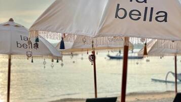 Na praia, praia de areia branca, espreguiçadeiras, guarda-sóis de praia