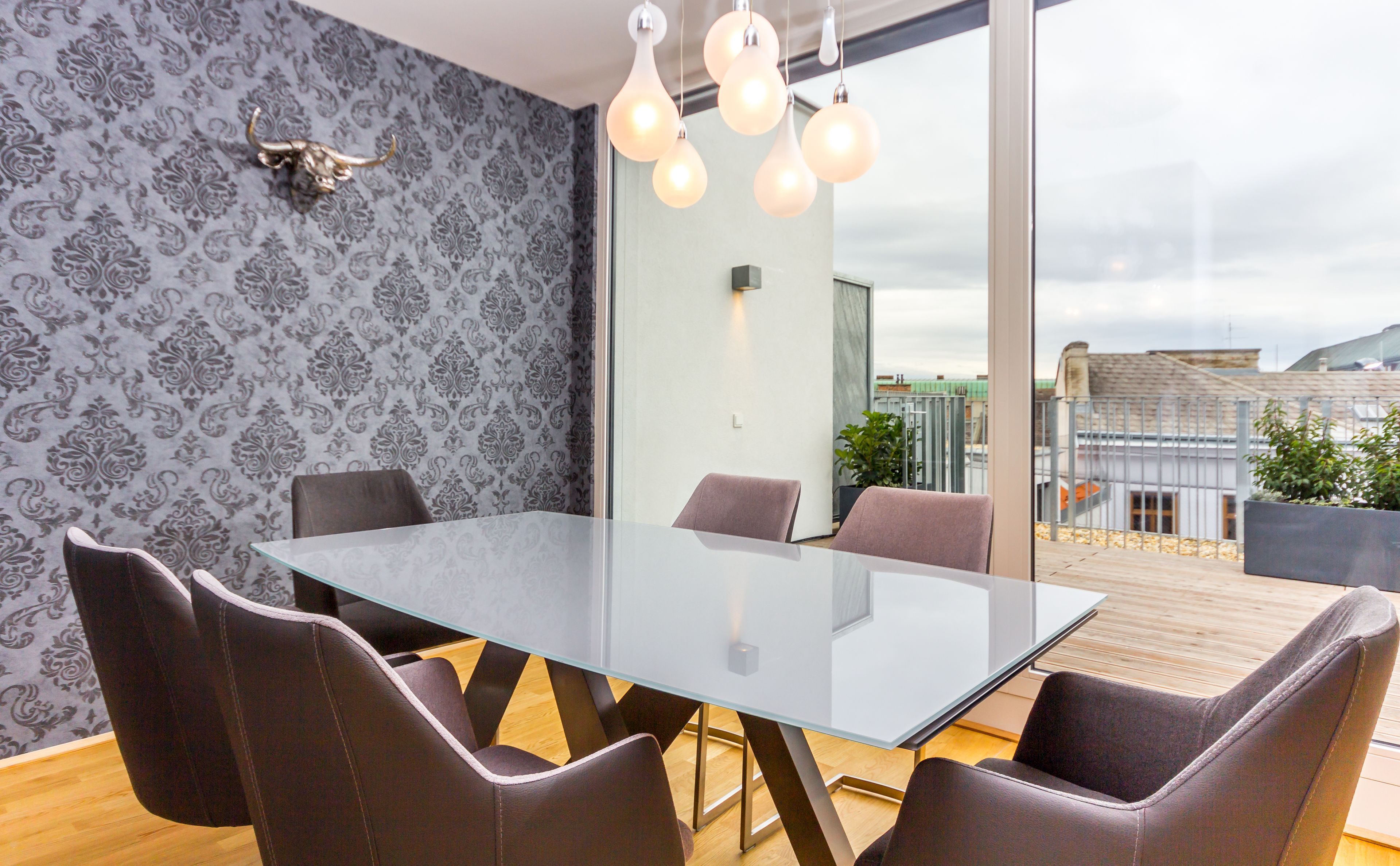 Uma sala de reuniões moderna com uma mesa de vidro e cadeiras de couro, grandes janelas com vista para a cidade e papel de parede estampado.