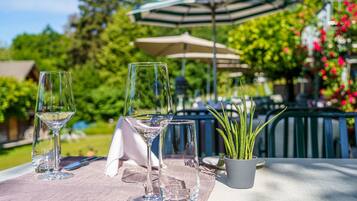 Uma mesa com copos de vinho vazios, uma guardanapo e uma planta em vaso.