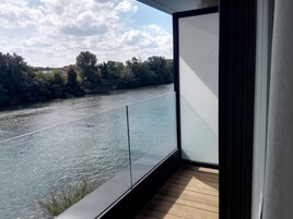 Uma varanda com vista para um rio e árvores.