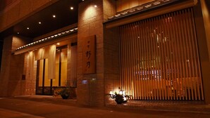 Um edifício com grandes janelas verticais e uma placa com caracteres chineses.