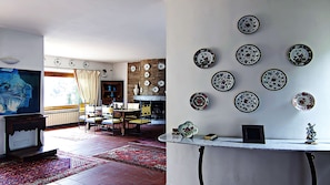 Uma sala de jantar com mesa, cadeiras, televisão e lareira.