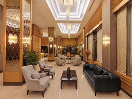 Um hall amplo com balcão de recepção, área de estar e um candelabro.