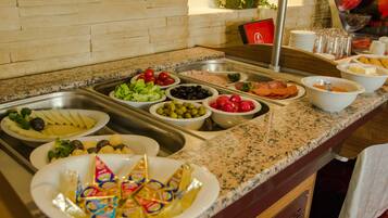 Buffet com diversos alimentos, incluindo frutas, vegetais e carnes.