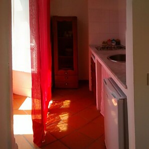 Apartamento, 1 quarto, cozinha americana | Cozinha privada | Geladeira grande, cooktop, talheres/pratos/utensílios de cozinha