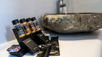 Exposição de produtos de cuidados com a pele e uma pia de pedra em um banheiro.