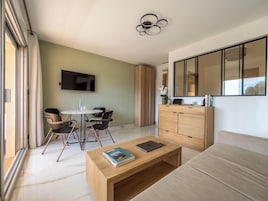 Apartamento Deluxe, vista parcial para o mar | Sala de estar | TV de ecrã plano 