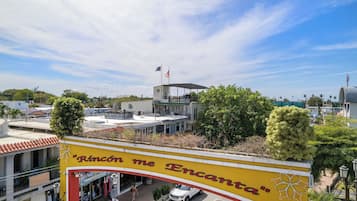 Um edifício com uma bandeira, uma área coberta e uma placa que diz 'Rincón me Encanta'.