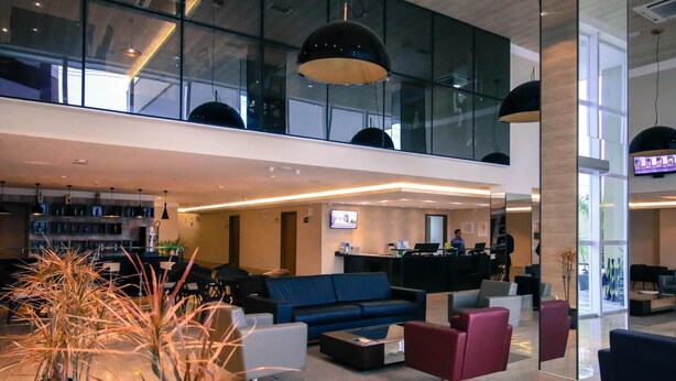 Um lobby moderno com balcão de recepção, área de estar e bar.