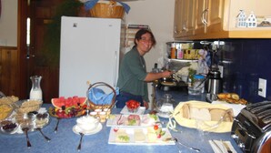 Cozinha com armários de madeira, geladeira e diversos alimentos sobre o balcão.