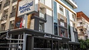 Um hotel de vários andares com fachada moderna, varandas e um café no térreo.
