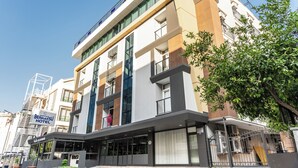 Um hotel moderno com estrutura em vários andares, grandes janelas e entrada destacada.