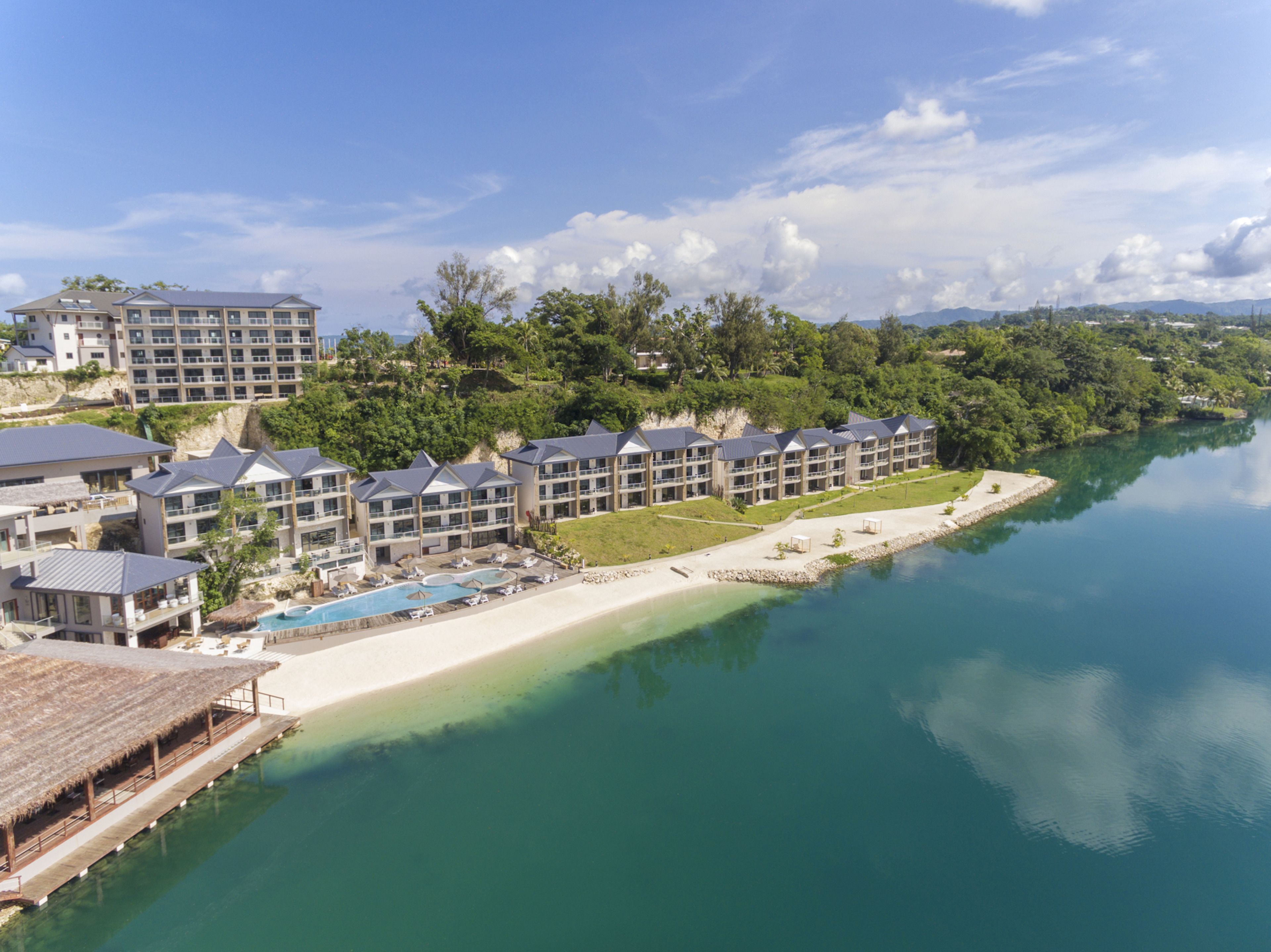 Resort com vários edifícios, piscina e praia.
