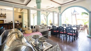 Restaurante com serviço de buffet, incluindo pratos de aço inoxidável e um balcão de buffet.