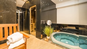 Uma área de spa moderna com um banco de madeira, uma piscina coberta pequena e uma entrada com paredes de vidro.