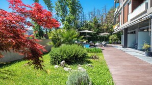 Um edifício moderno com jardim, área de estar ao ar livre e piscina.