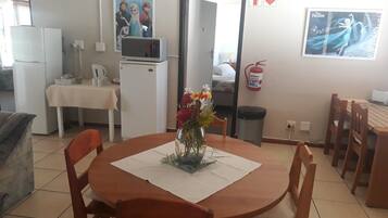 Uma placa de cozinha, uma cafeteira/bule, uma chaleira elétrica
