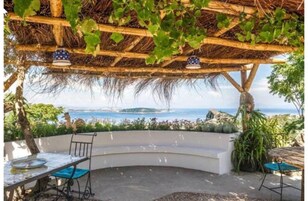 Uma área de estar coberta ao ar livre com vista para o mar.