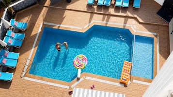 Piscina com espreguiçadeiras e posto de salva-vidas.