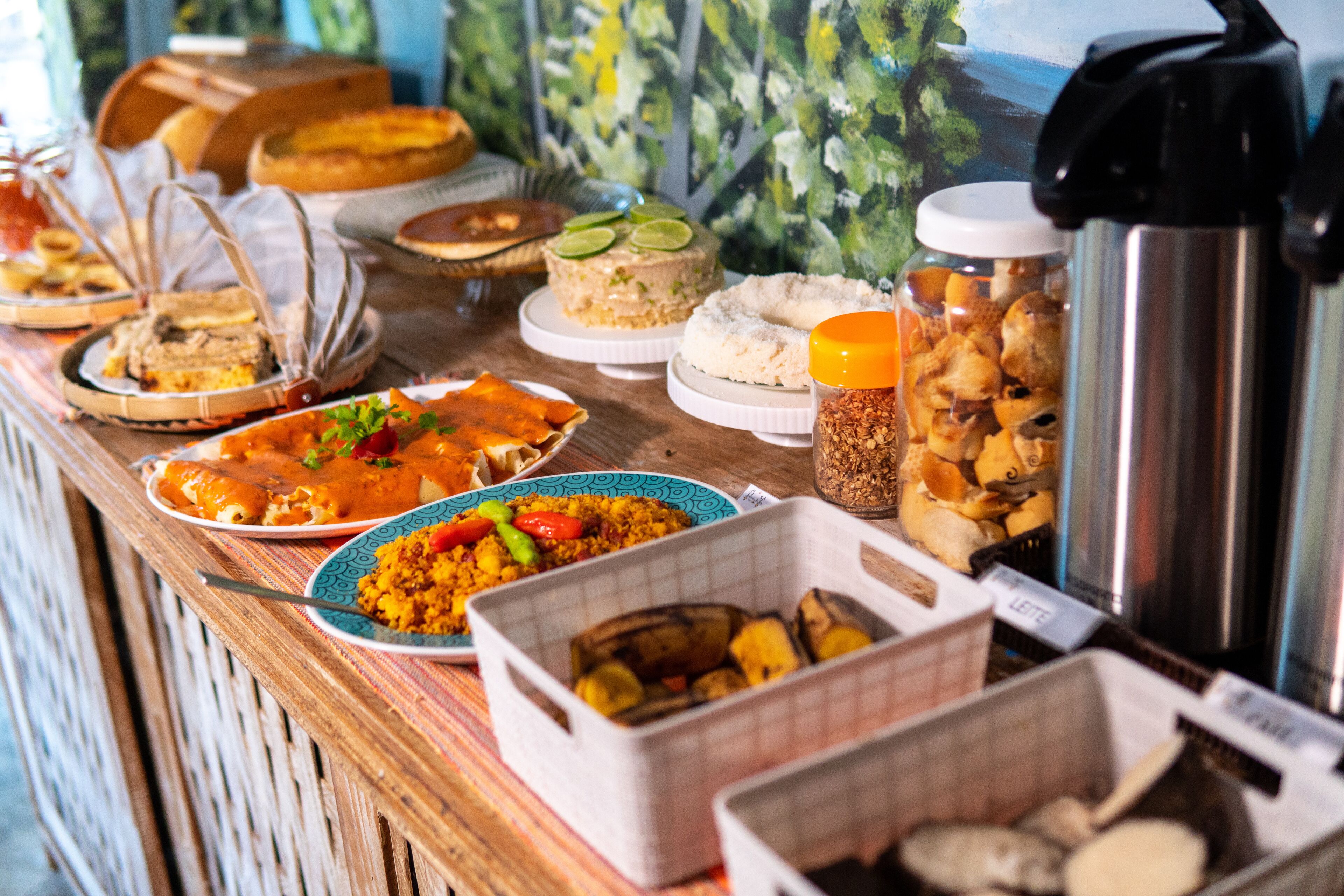 Buffet variado com diversos pratos, incluindo um bolo com fatias de limão, uma tigela de arroz e um recipiente com frutos secos.