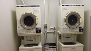 Duas secadoras Sanyo automáticas lado a lado numa lavanderia pública.