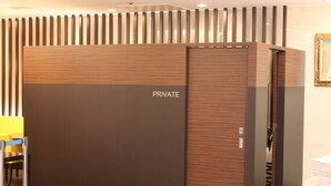 Quarto privativo com detalhe em painel de madeira, porta com puxador e um número pequeno.