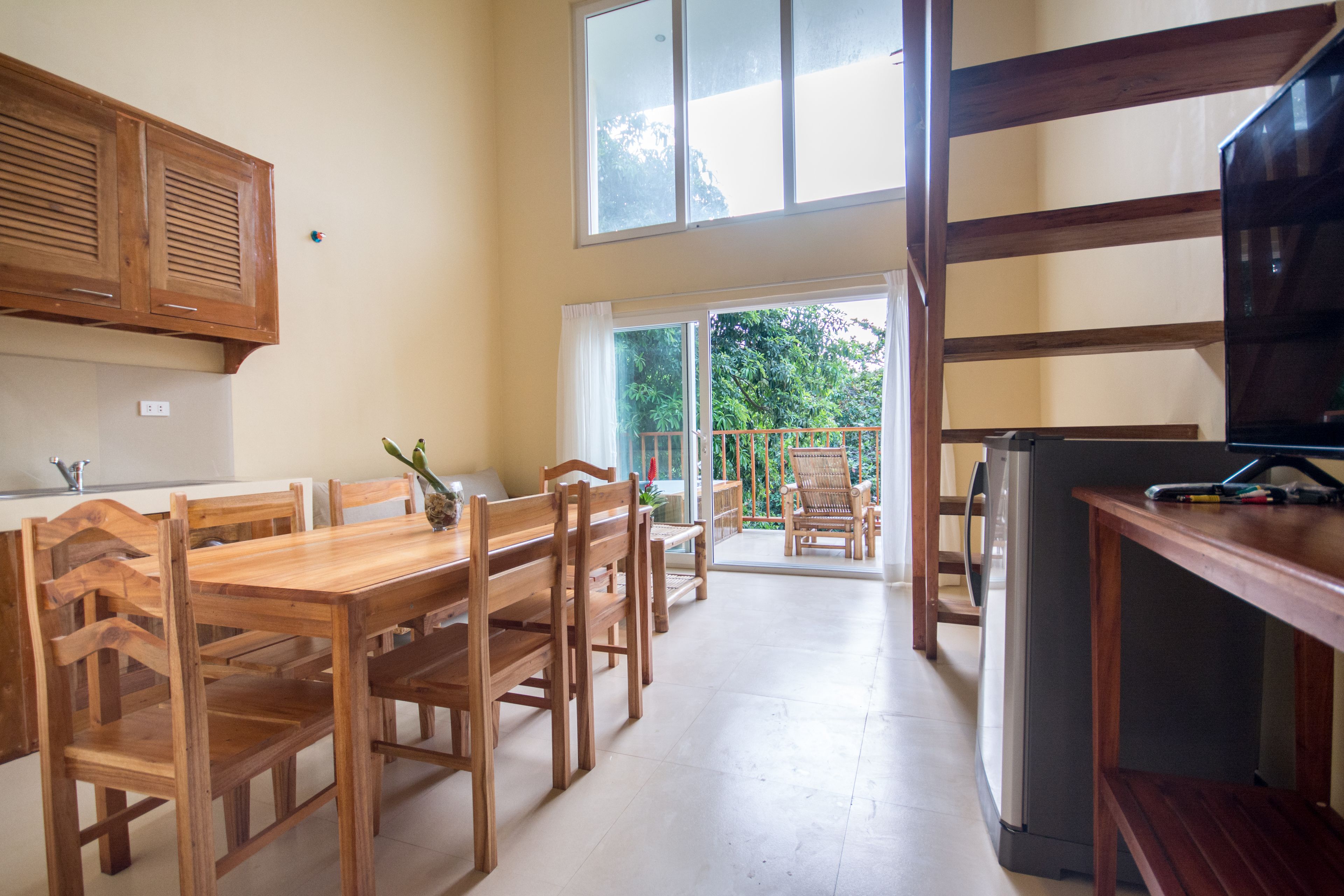 Cozinha espaçosa com mobili ário de madeira, uma janela ampla e vista para o verde lá fora.