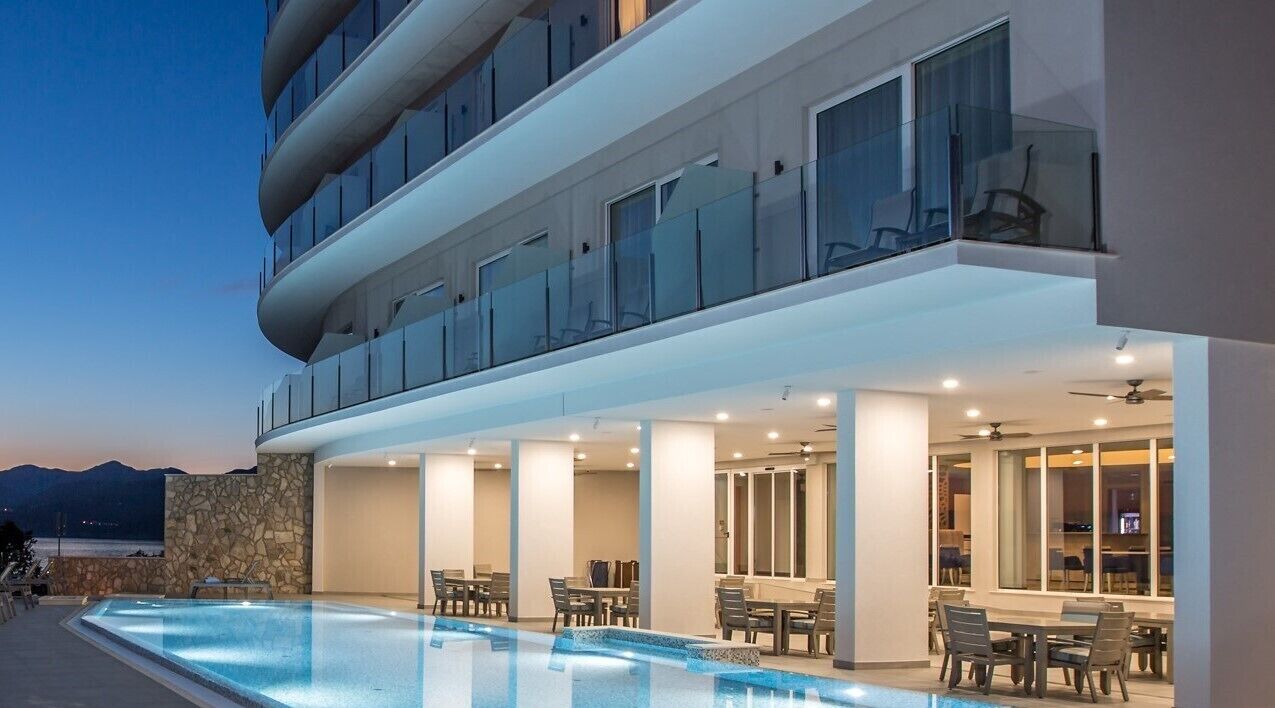 Um hotel moderno com piscina, área de estar externa e vista para as montanhas.