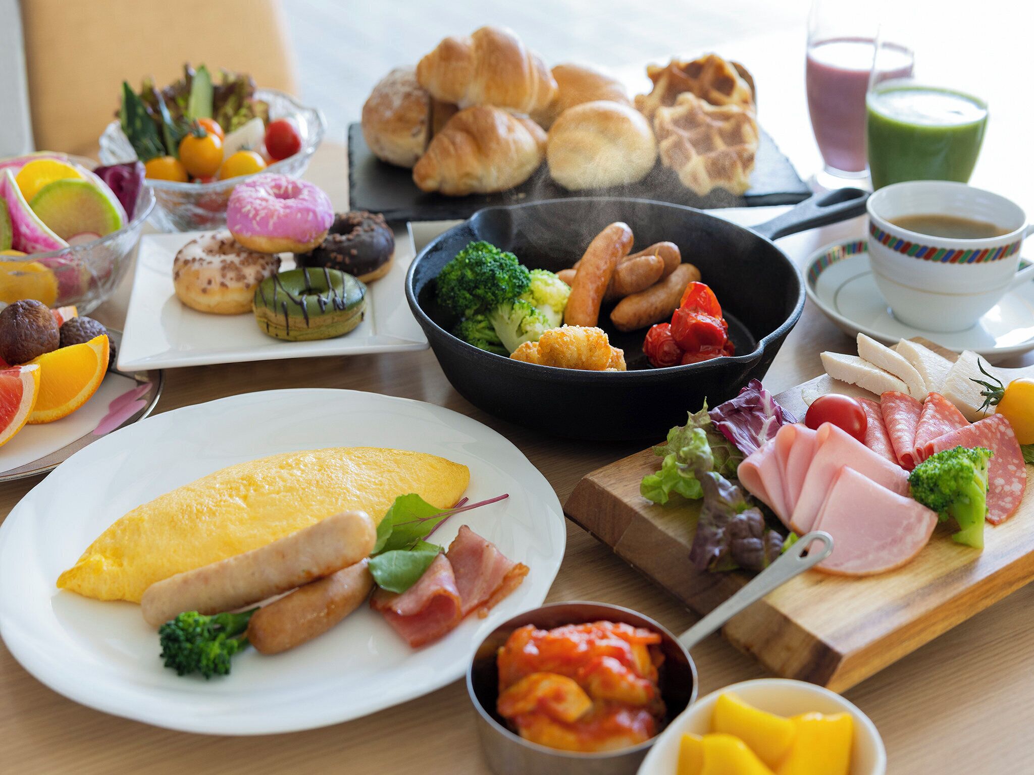 Um buffet de café da manhã com diversos pratos, incluindo ovos, carnes, vegetais, pães e bebidas.