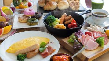 Um buffet de café da manhã com diversos pratos, incluindo ovos, carnes, vegetais, pães e bebidas.