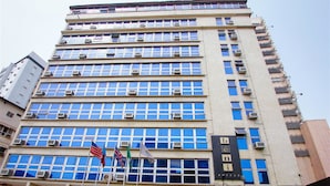 Um hotel com vários andares e uma placa bem visível indicando que é um hotel.