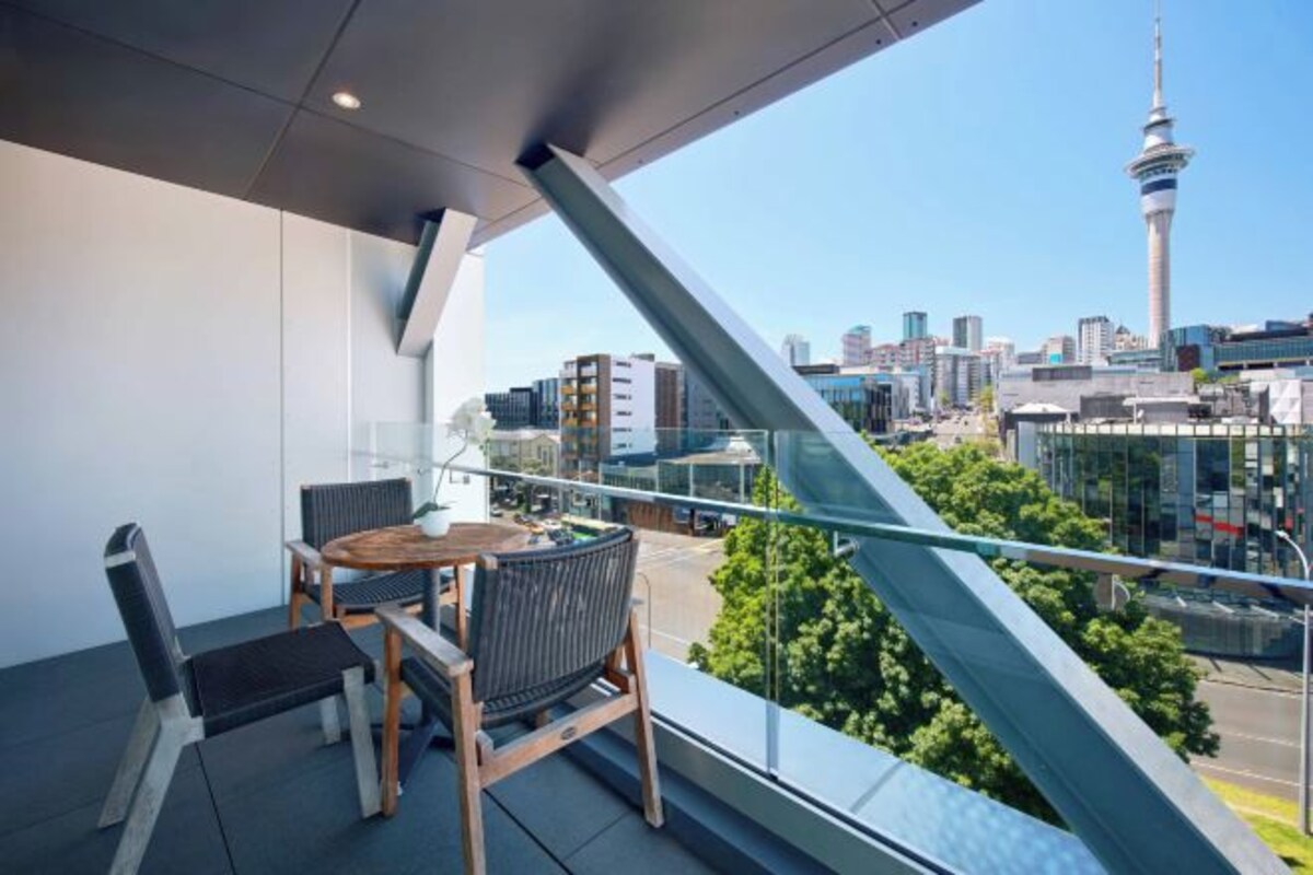 Uma varanda com vista para o horizonte urbano, incluindo uma torre imponente.