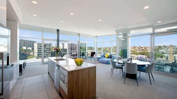 Um apartamento moderno com cozinha, sala de jantar e área de estar, com janelas amplas e vista para a cidade.