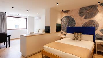 Quarto de hotel moderno com uma cama grande, uma escrivaninha e vista para a cidade.
