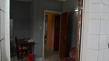 Um quarto com uma mesa de jantar, cadeiras, uma cesta vermelha e um sofá estampado.
