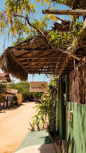 Um edifício rústico com telhado de palha e uma placa com a inscrição "Usada Lavie".