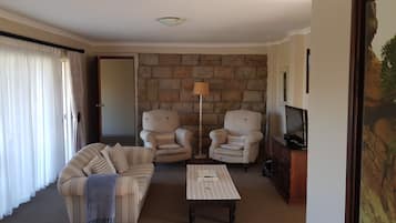 Suíte lua de mel, 1 quarto | Sala de estar | TV de tela plana 32 polegadas com canais de TV premium, TV