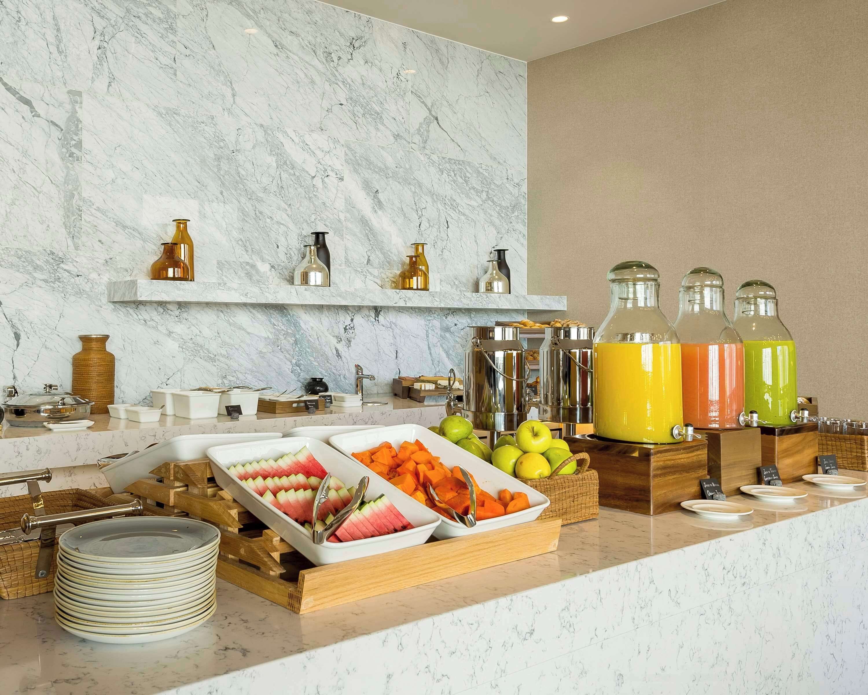 Uma mesa de buffet com diversos alimentos e bebidas.
