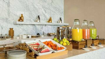 Uma mesa de buffet com diversos alimentos e bebidas.