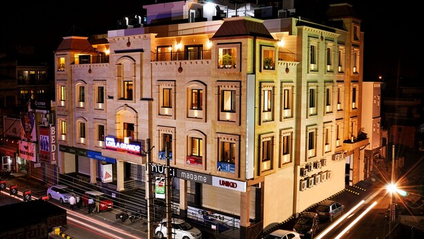Um edifício com vários andares e espaços comerciais no andar térreo, incluindo um restaurante e uma loja.
