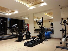 Uma academia com diversos equipamentos de exercício, incluindo esteiras, elípticos e bicicletas ergométricas.