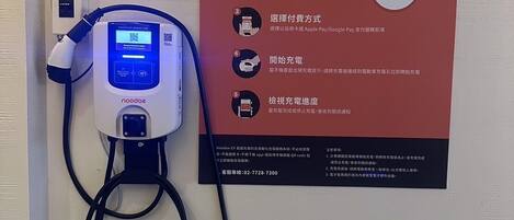 Estação de carregamento inteligente para veículos elétricos noodoe, com código QR para iPhone e Android, taxa de 50 RMB por hora e número de contato para informações.