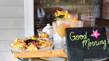 Uma mesa de café da manhã com ovos mexidos, torradas e um letreiro com a mensagem 'Bom dia'.