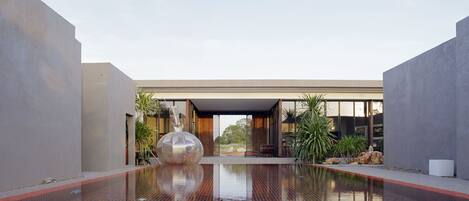 Um edifício moderno com piscina refletora e design minimalista.