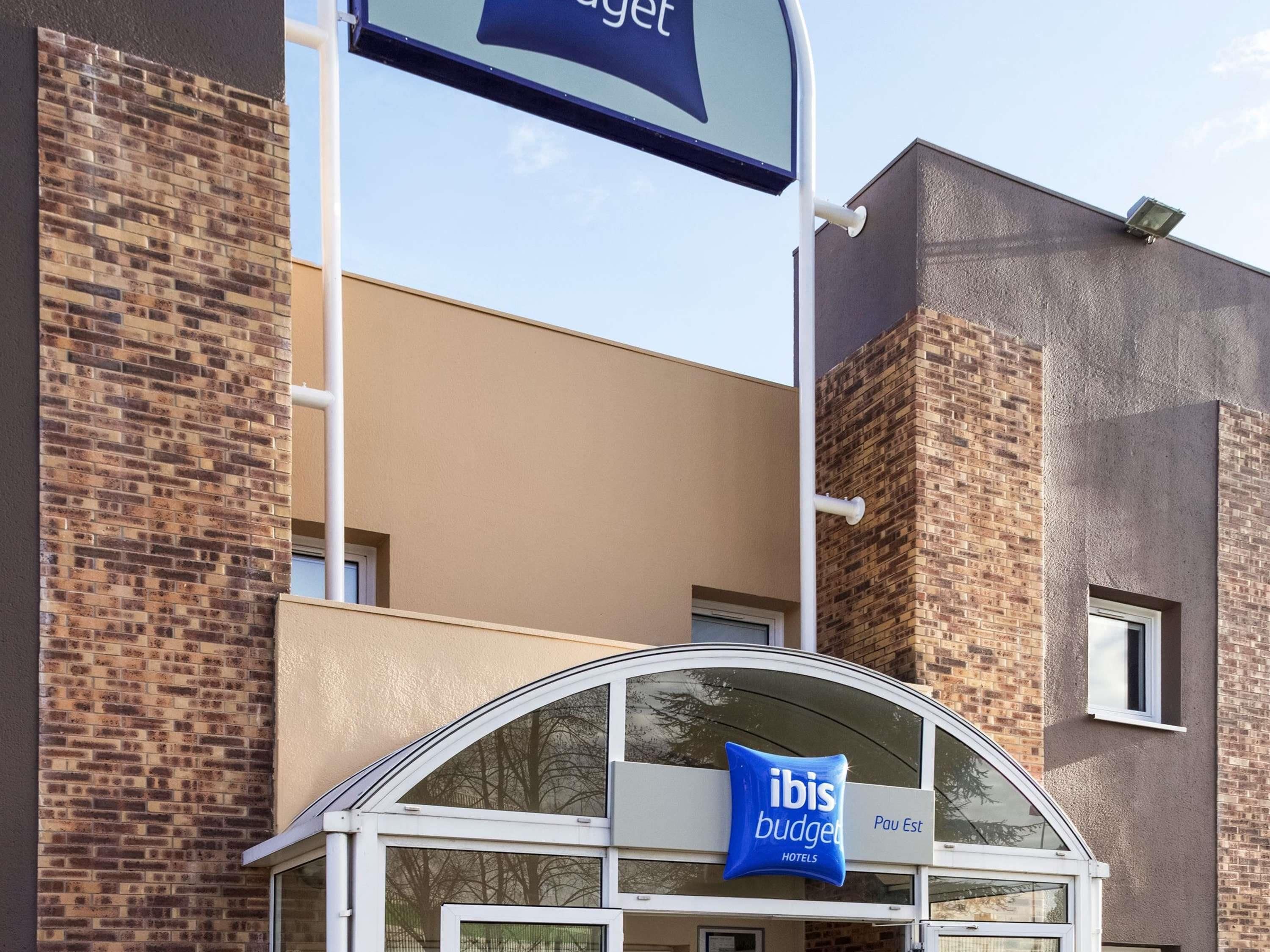 Entrada de hotel com placa indicando ibis budget hotels.