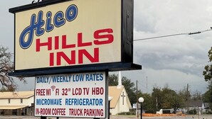 Um outdoor do Hico Hills Inn anunciando tarifas diárias/semanais imbatíveis, Wi-Fi gratuito, TV LCD de 32 polegadas, HBO, micro-ondas, geladeira, café na suíte e estacionamento para caminhões.