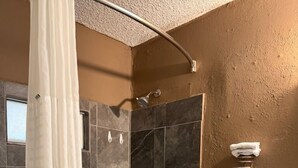 Um banheiro com banheira, vaso sanitário e chuveiro.